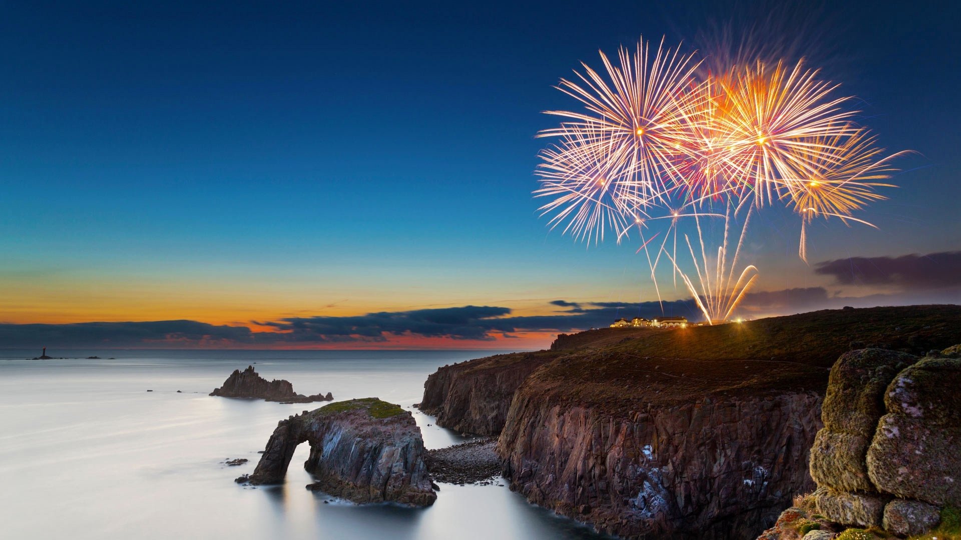 Spectacular Night Fireworks Over Ocean Arch Horizon – HD Coastal Wallpaper