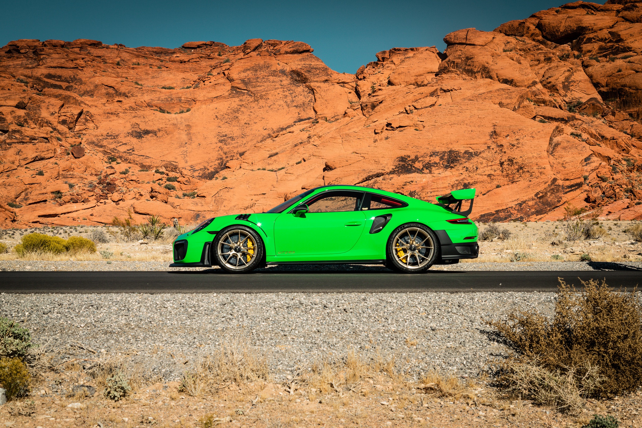 Stunning Green Porsche 911 GT3 Racing Against Desert Cliffs – HD Wallpaper